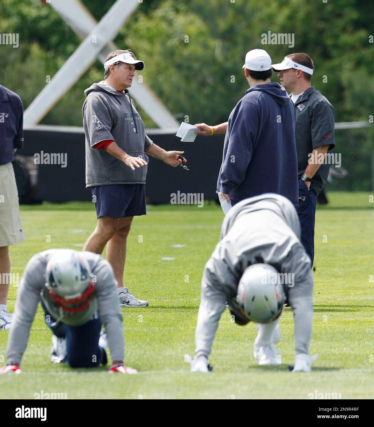 New England Patriots head coach Bill Belichick talks with his coaches ...