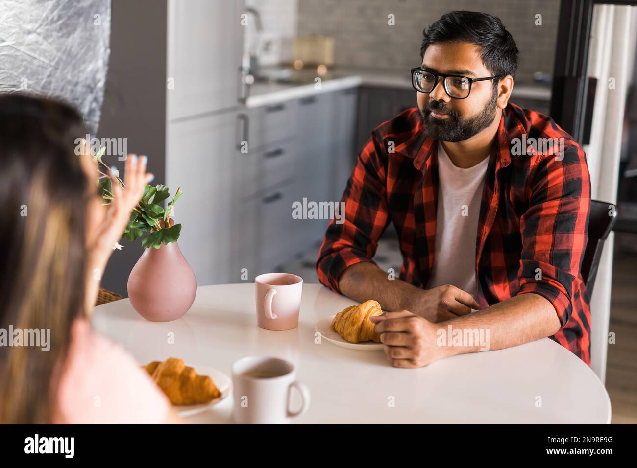 Happy indian couple having breakfast and small talk together in the ...