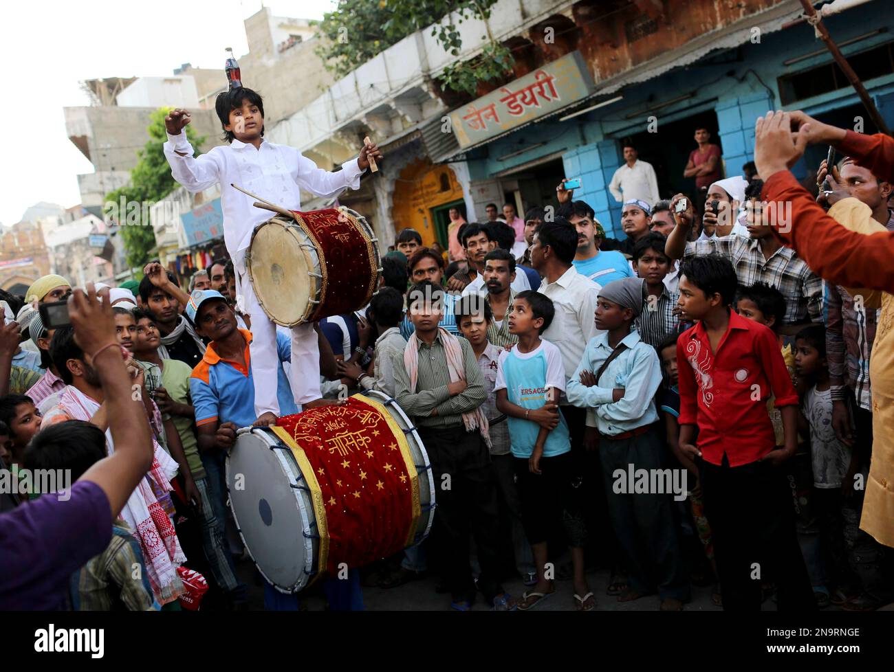 A young Indian Muslim Sufi performer balances a soft drink bottle on ...