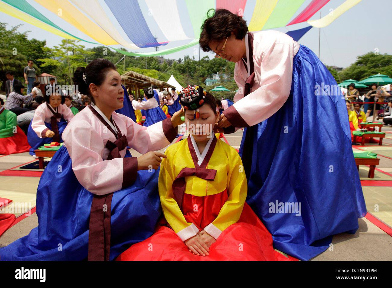 Two women assist a girl at the 40th Coming of Age Day ceremony, known ...