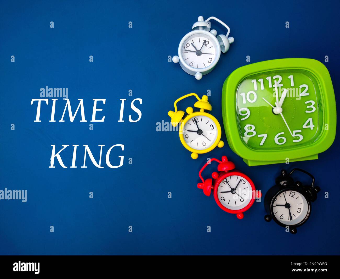 A Top view of alarm clocks with the word TIME IS KING on blue ...