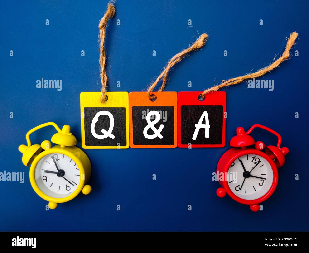 The red and yellow Alarm clocks and colored wooden boards with the word ...