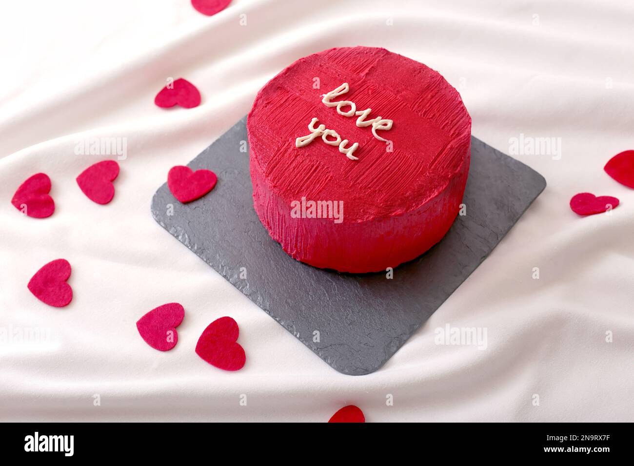 round tasty red bento cake lie on white bed Stock Photo - Alamy