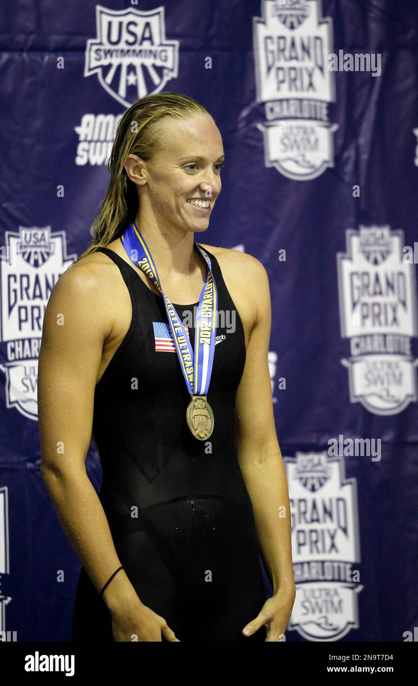 Dana Vollmer stands atop the medal platform with her first place medal ...
