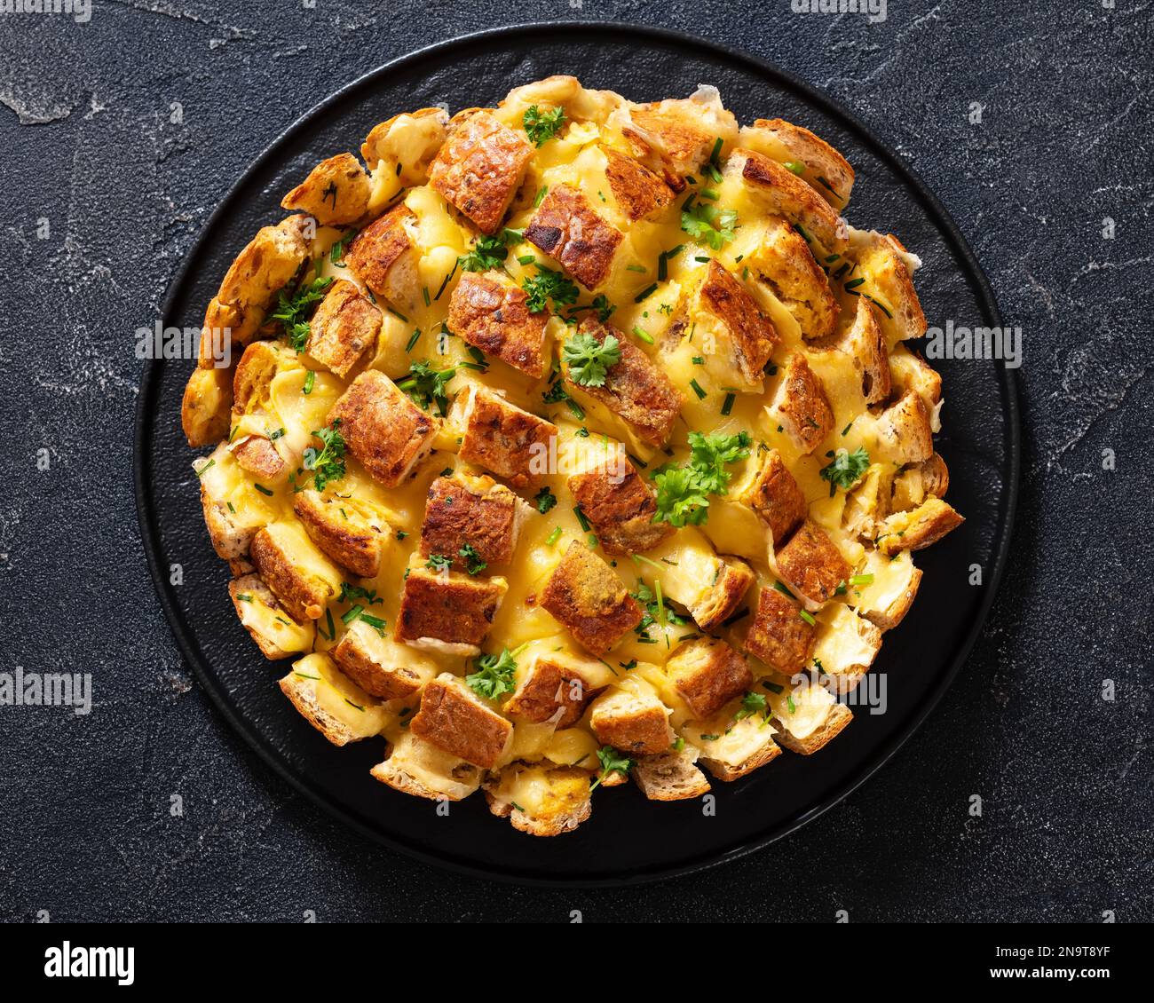 cheesy garlic crusty bread, pull apart whole round bread on black ...