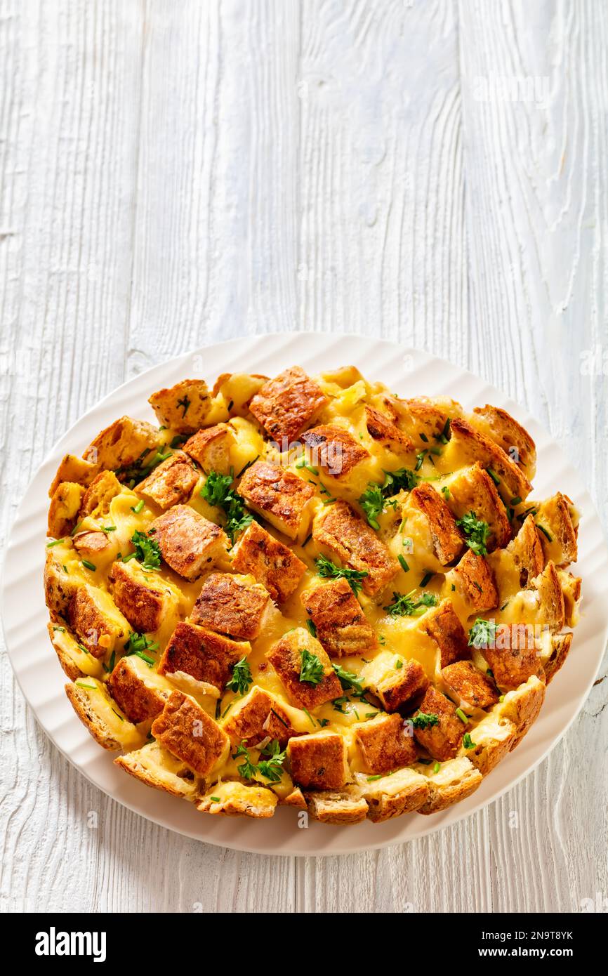 cheesy garlic bread, pull apart whole round bread on white platter on ...