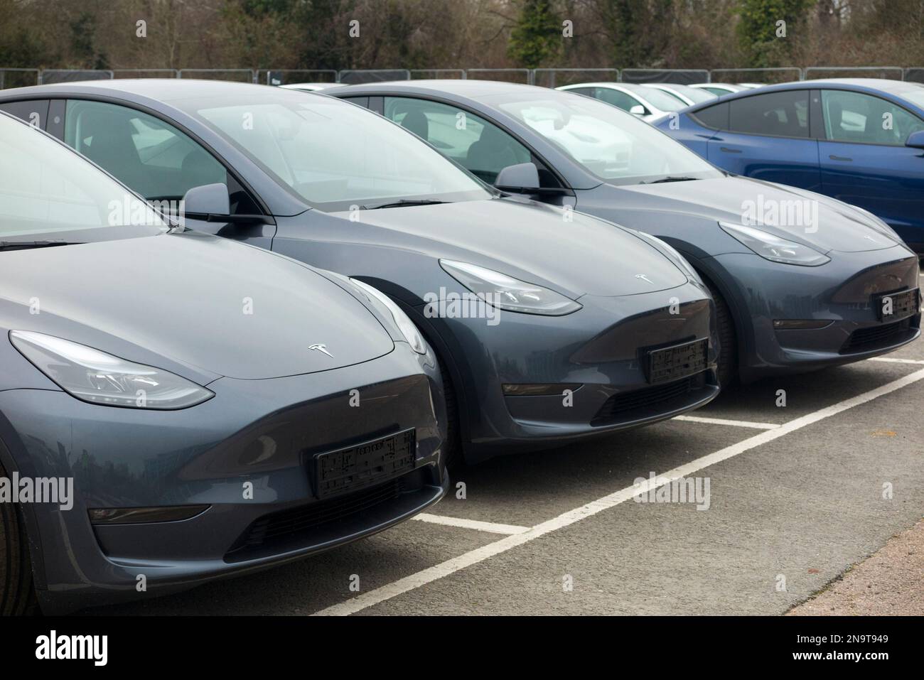 Tesla Electric vehicle EV cars waiting at a delivery collection car hub ...