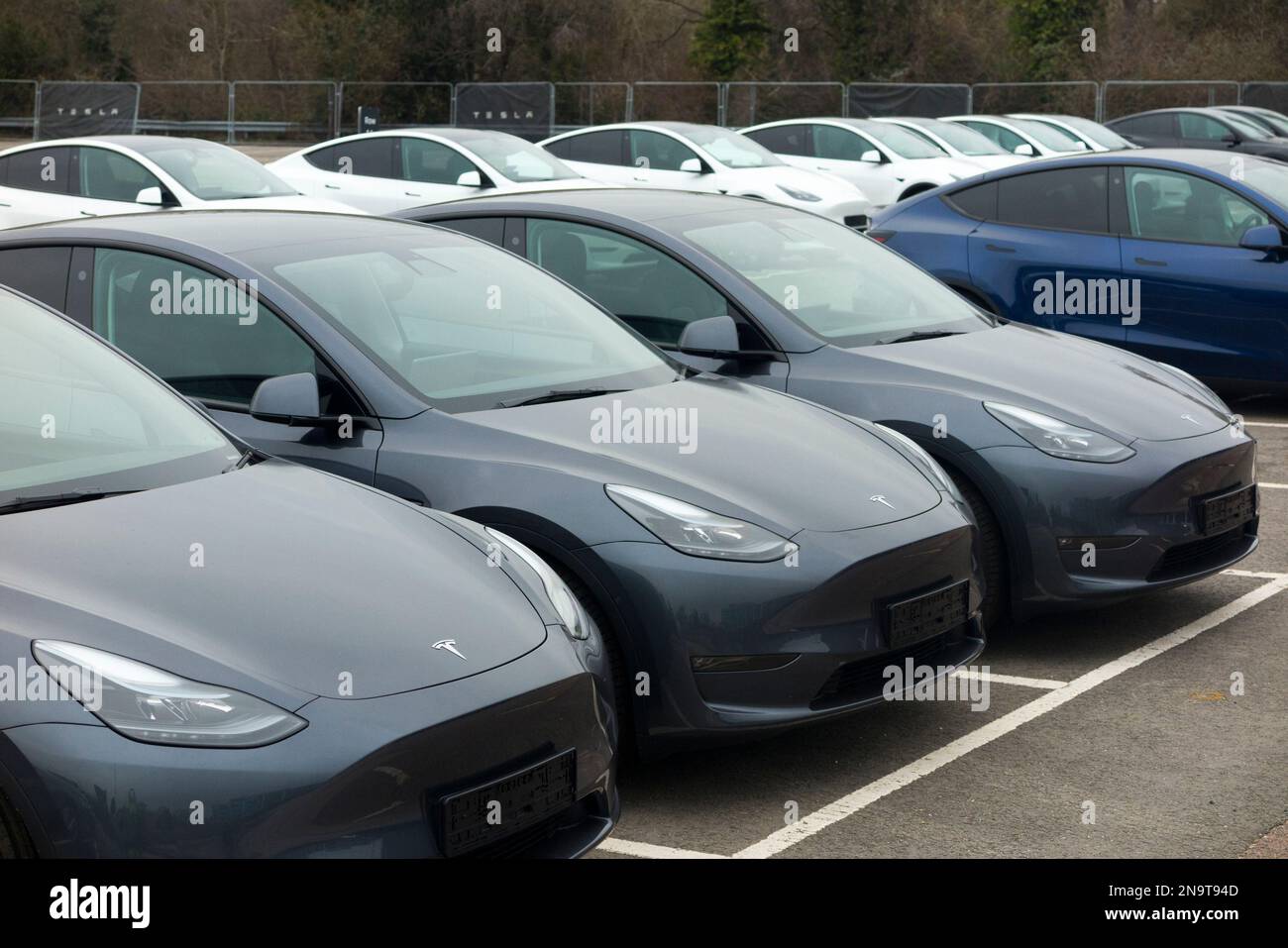 Tesla Electric vehicle EV cars waiting at a delivery collection car hub ...