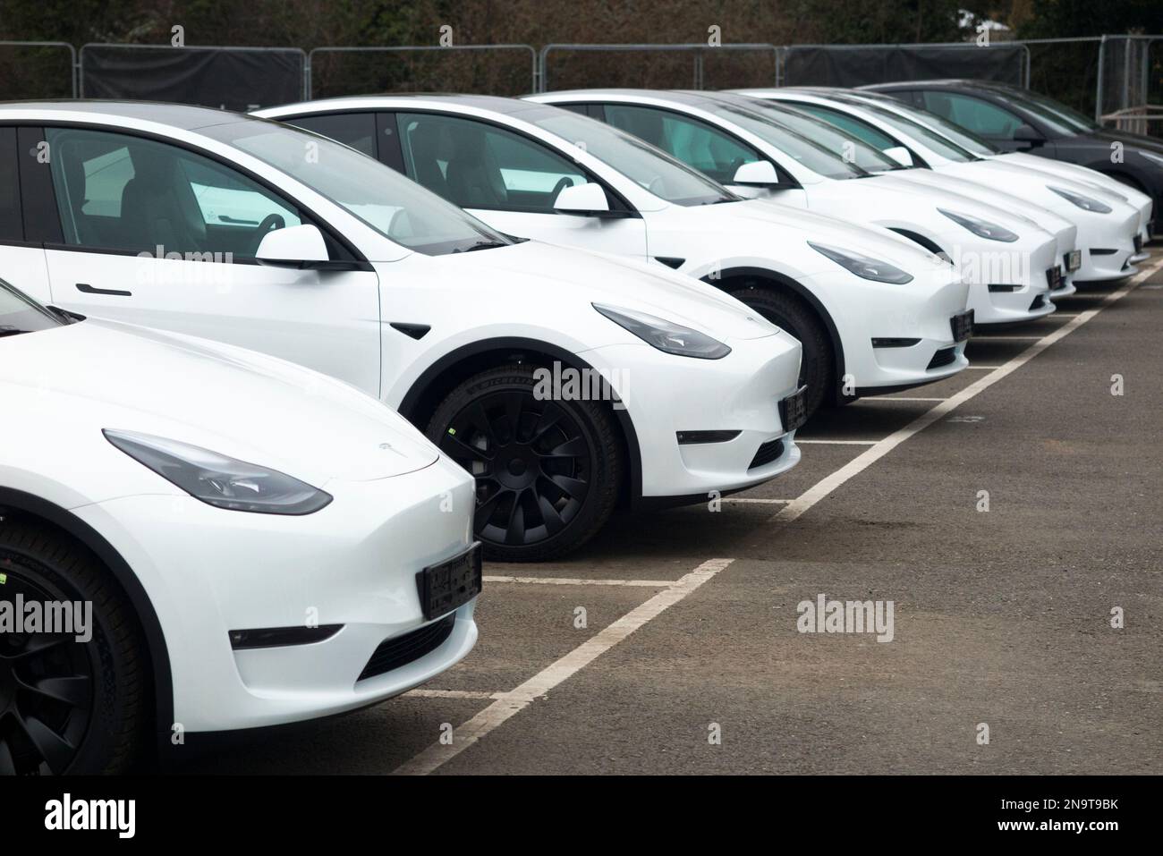 Tesla Electric vehicle EV cars waiting at a delivery collection car hub ...