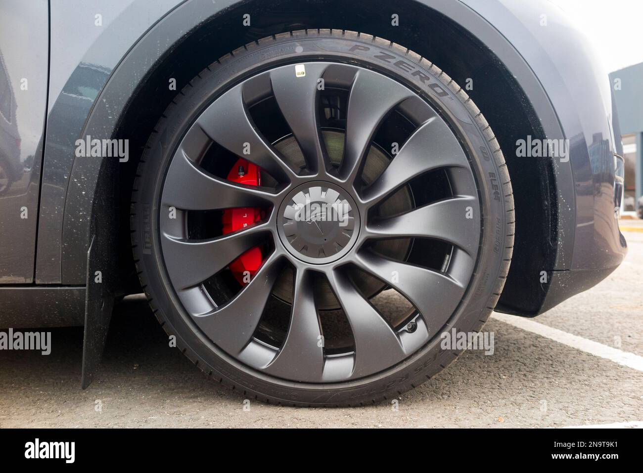 Front wheel with a red brake mechanism on a Tesla electric vehicle ...