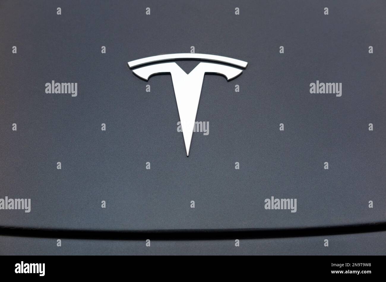 The Tesla logo insignia badge on the bonnet of an EV vehicle at a ...