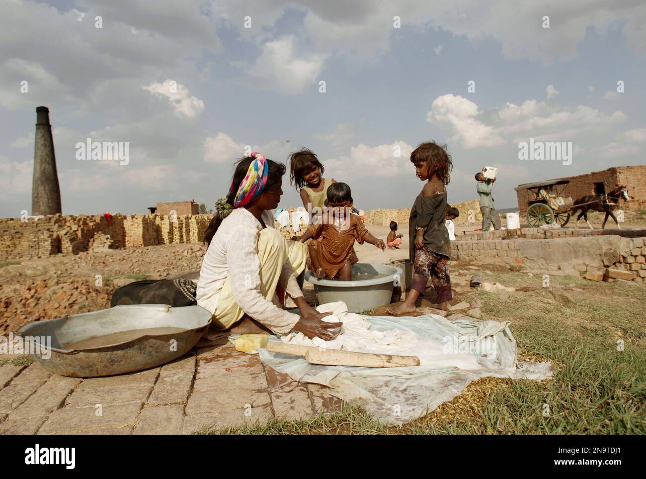 Pakistani Parveen,Allah Ditta, 34, left, washes her laundry while her ...