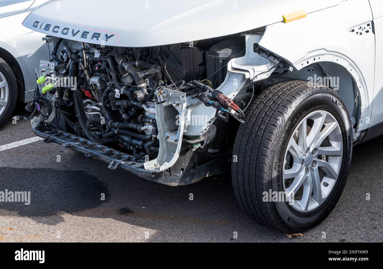 A white Land Rover Discovery SUV at a dealership with front end damage ...