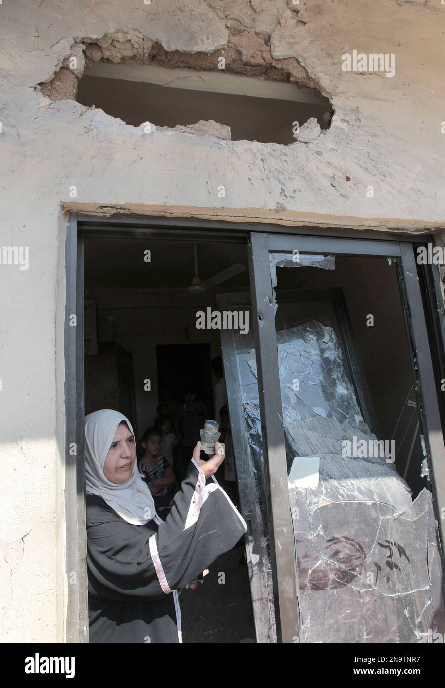 A Lebanese woman, holds a piece of shrapnel from an RPG which hit the ...