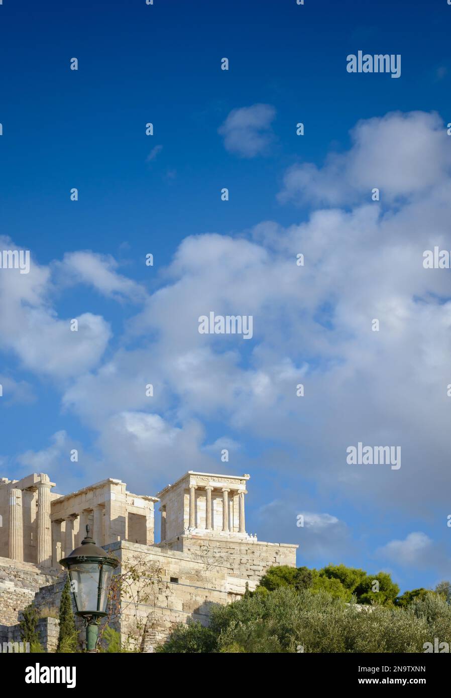 View of part of the Acropolis against a blue sky with white clouds ...