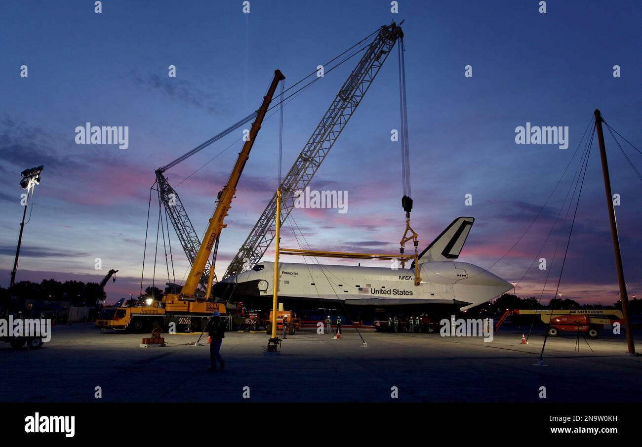 The sun rises as the space shuttle Enterprise rests on a specialized ...