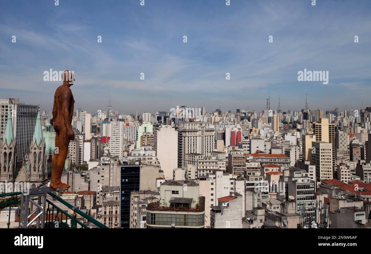 A sculpture by British artist Antony Gormely installed atop a building ...