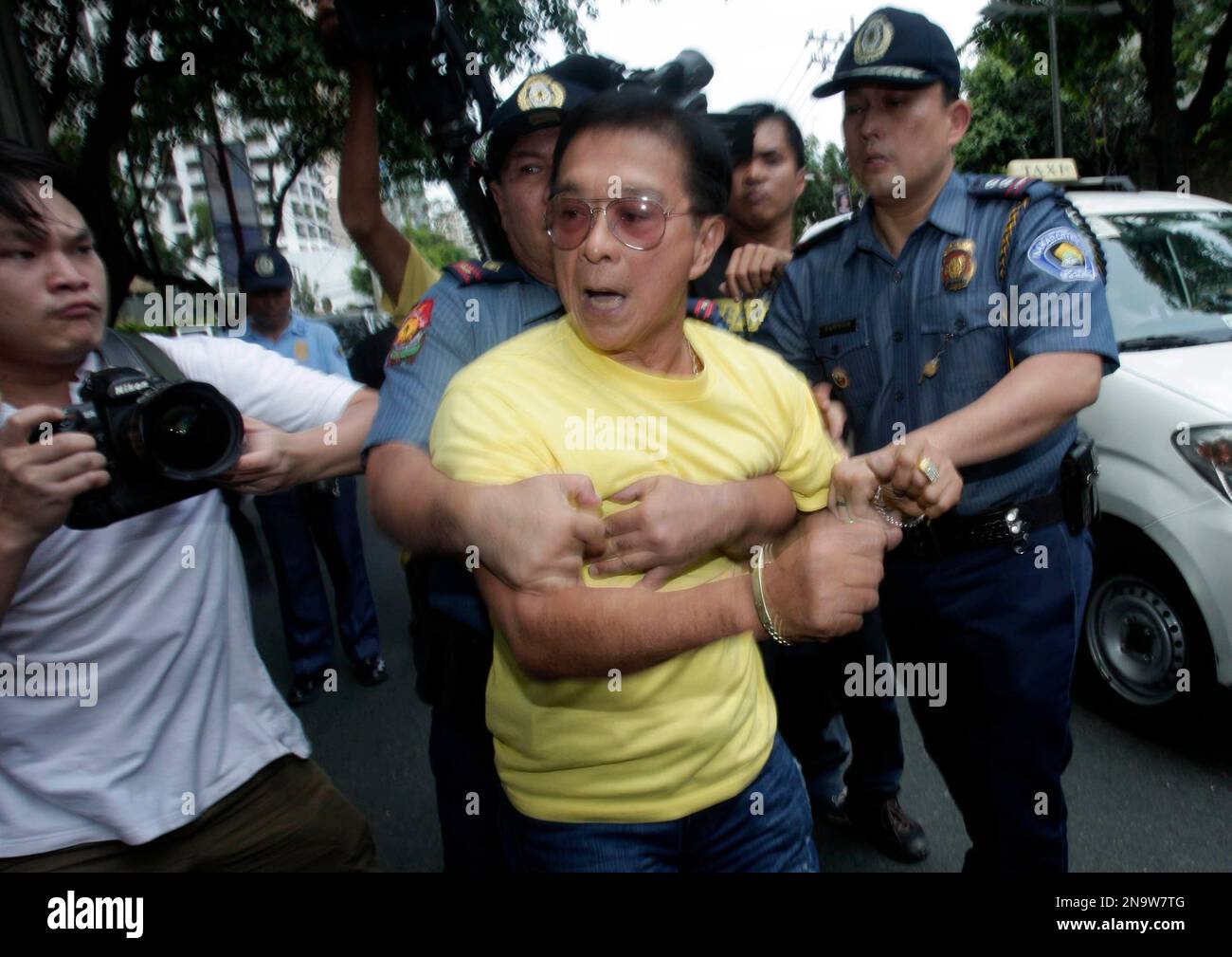Abner Afuang, a former policeman, is stopped by police from burning a ...