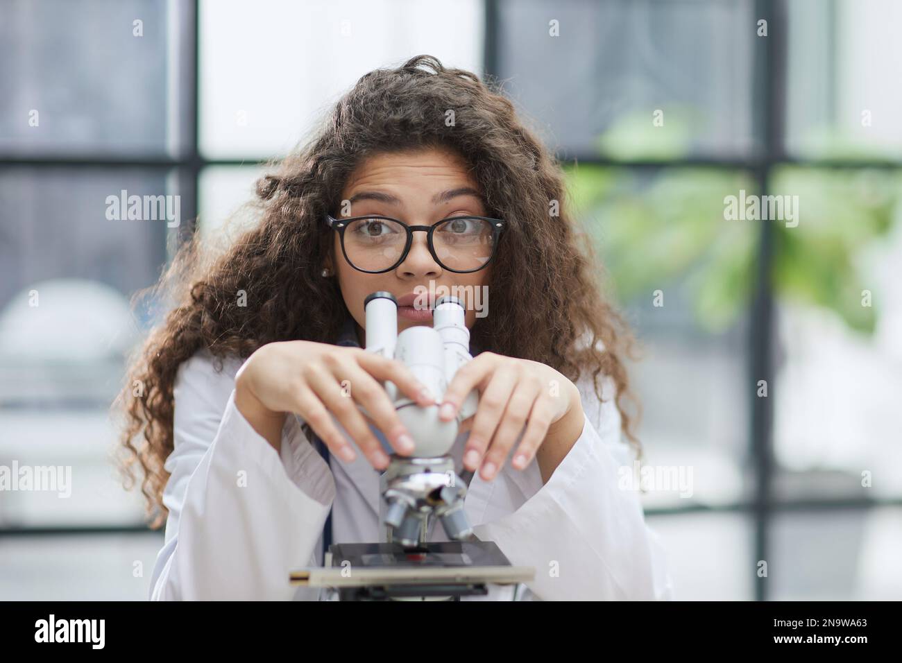Attractive female scientist looking through a microscope Stock Photo ...