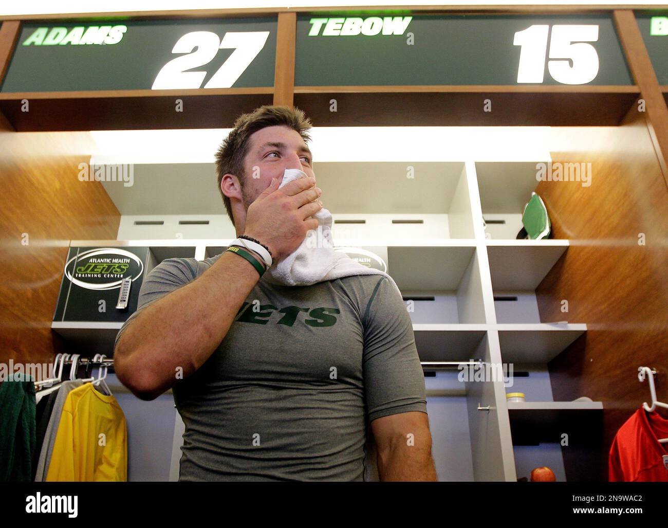 New York Jets quarterback Tim Tebow wipes sweat off his face while ...