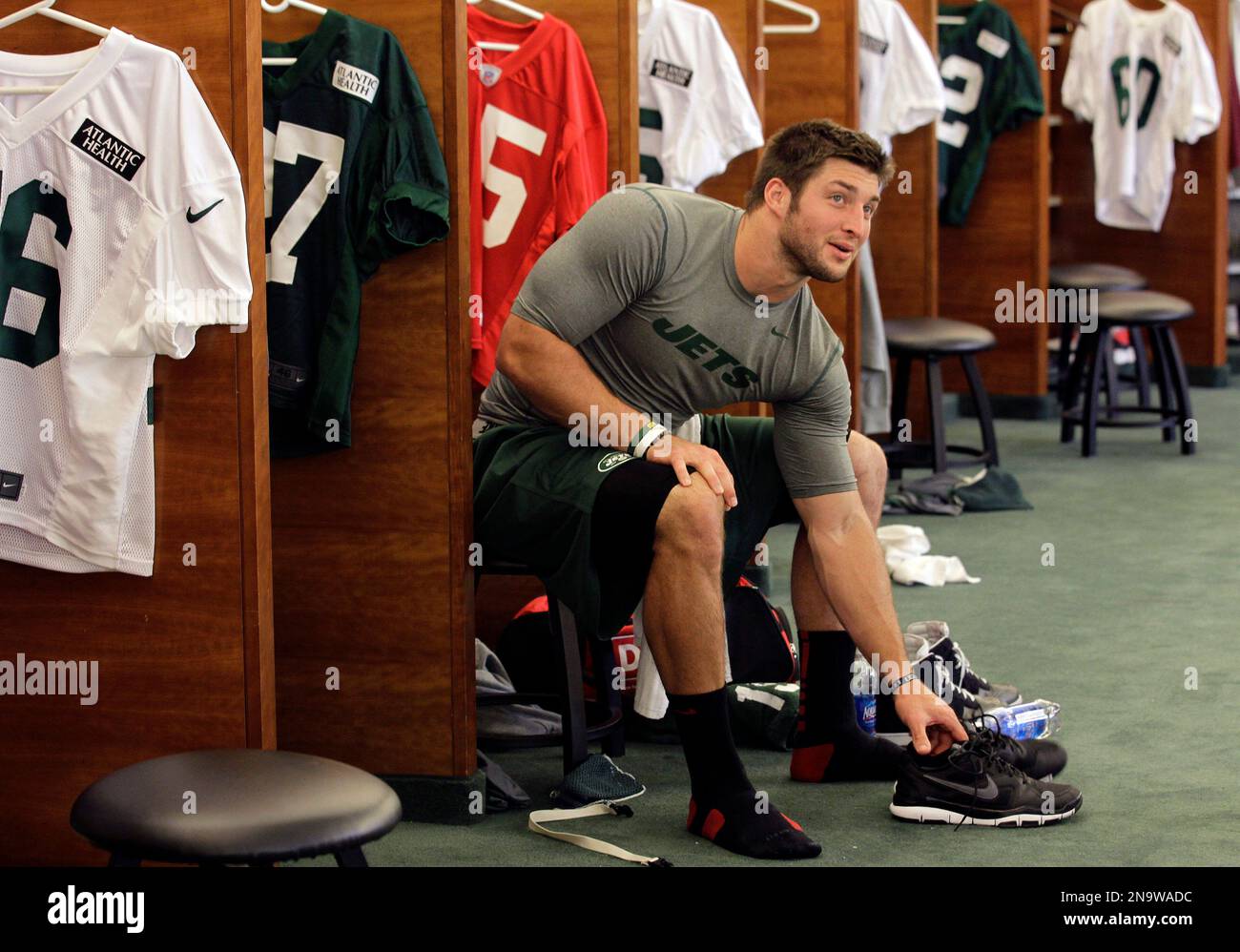 New York Jets quarterback Tim Tebow sits at his locker at the teams ...