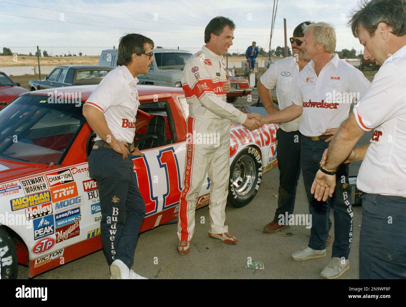 Darrell Waltrip , center, gets a handshake from a member of his crew ...