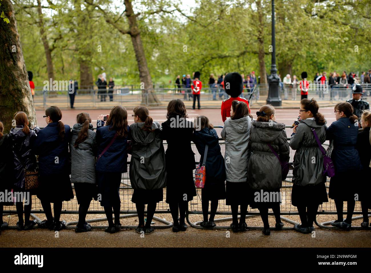 School girls wait to catch a glimpse of Britain's Queen Elizabeth II as ...