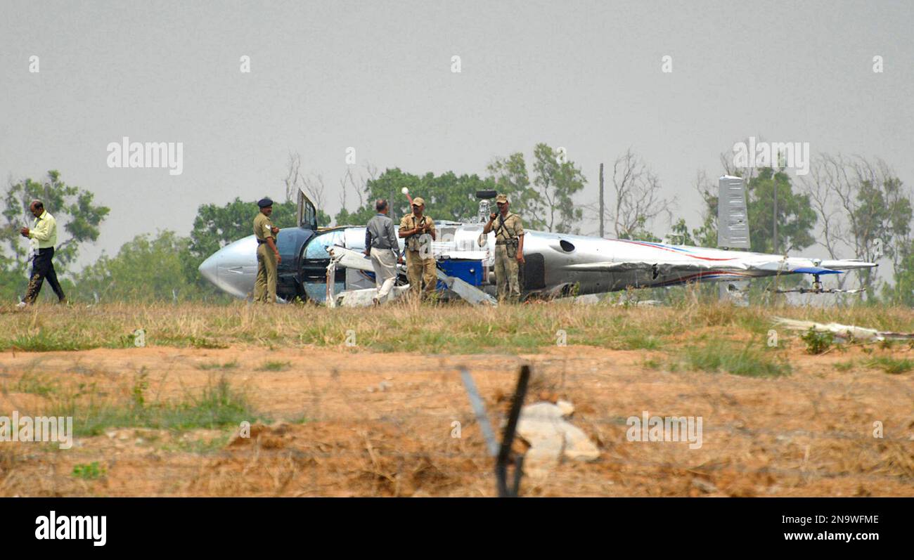 Security personnel stand near the wreckage of a helicopter after it ...