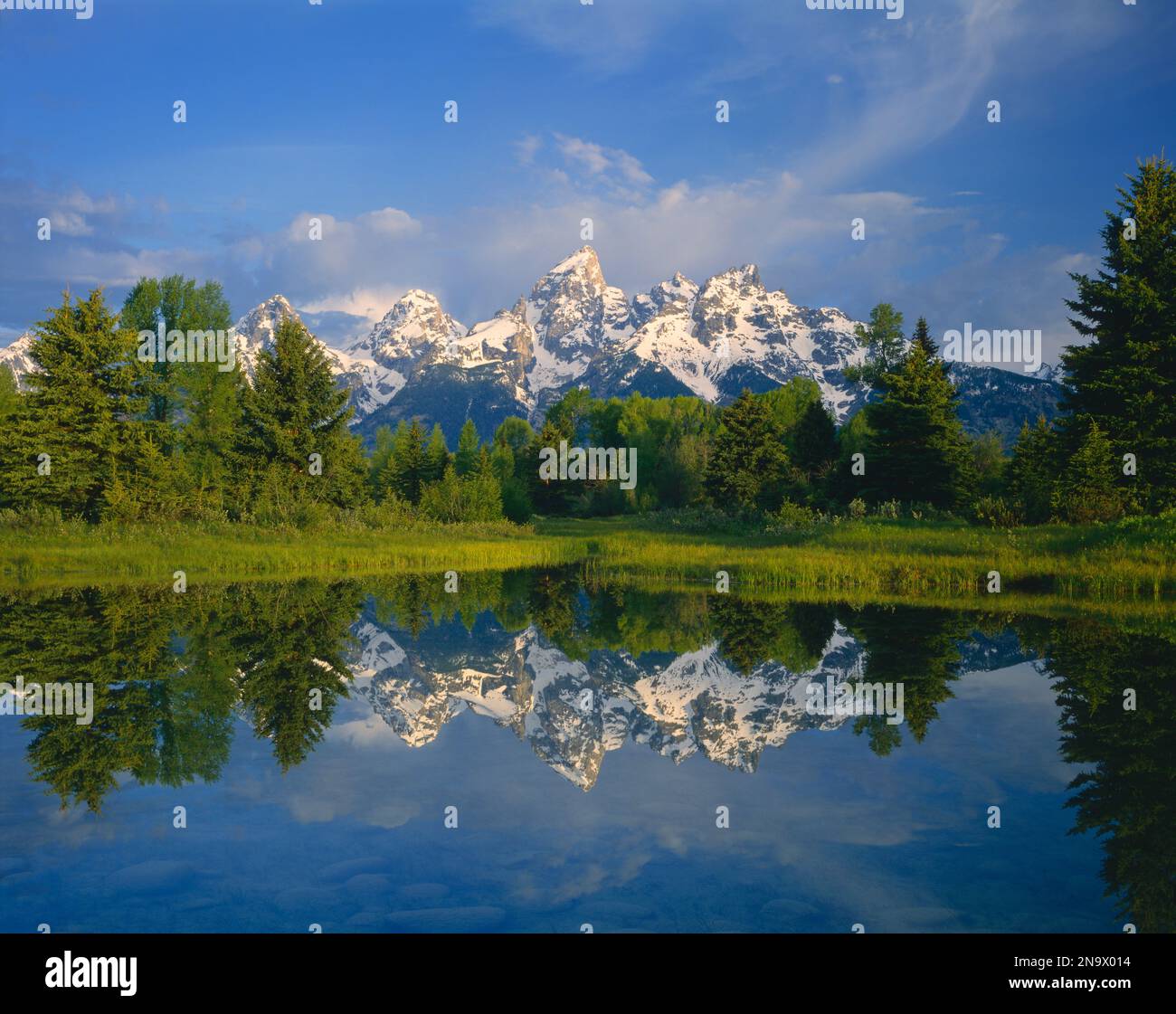 Rugged peaks of the Tatoosh Range with snow reflected in tranquil water ...