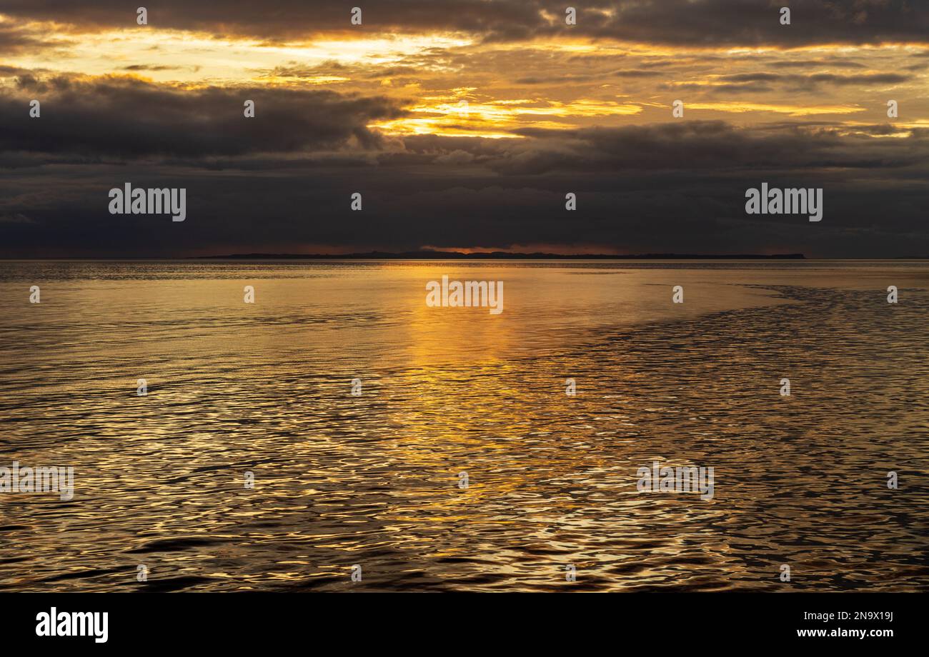 Golden sunset above a mirror like surface of the Pacific Ocean Stock ...