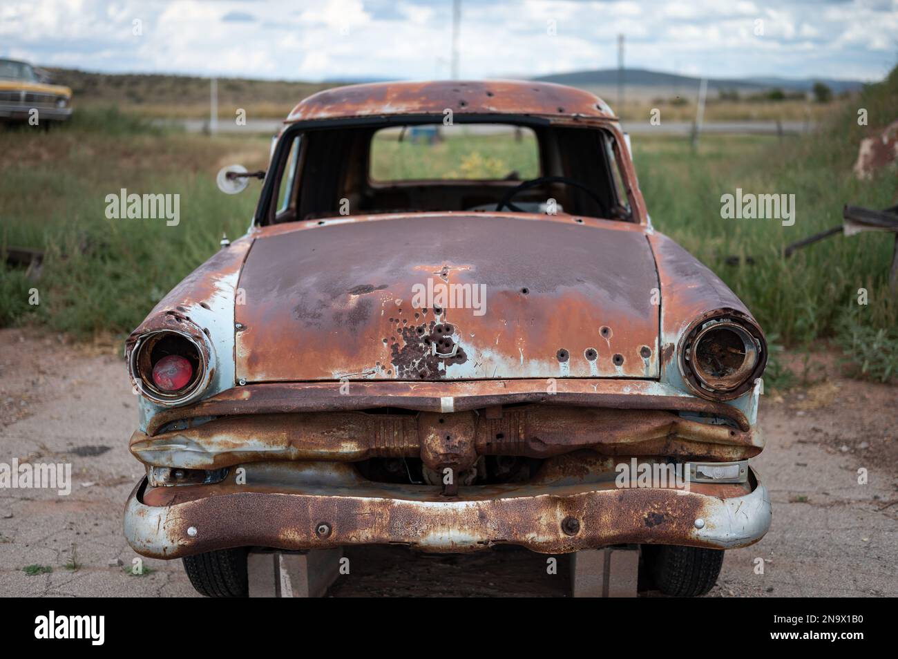 An old abandoned Ford Courier Sedan Delivery, rusty and with bullet ...