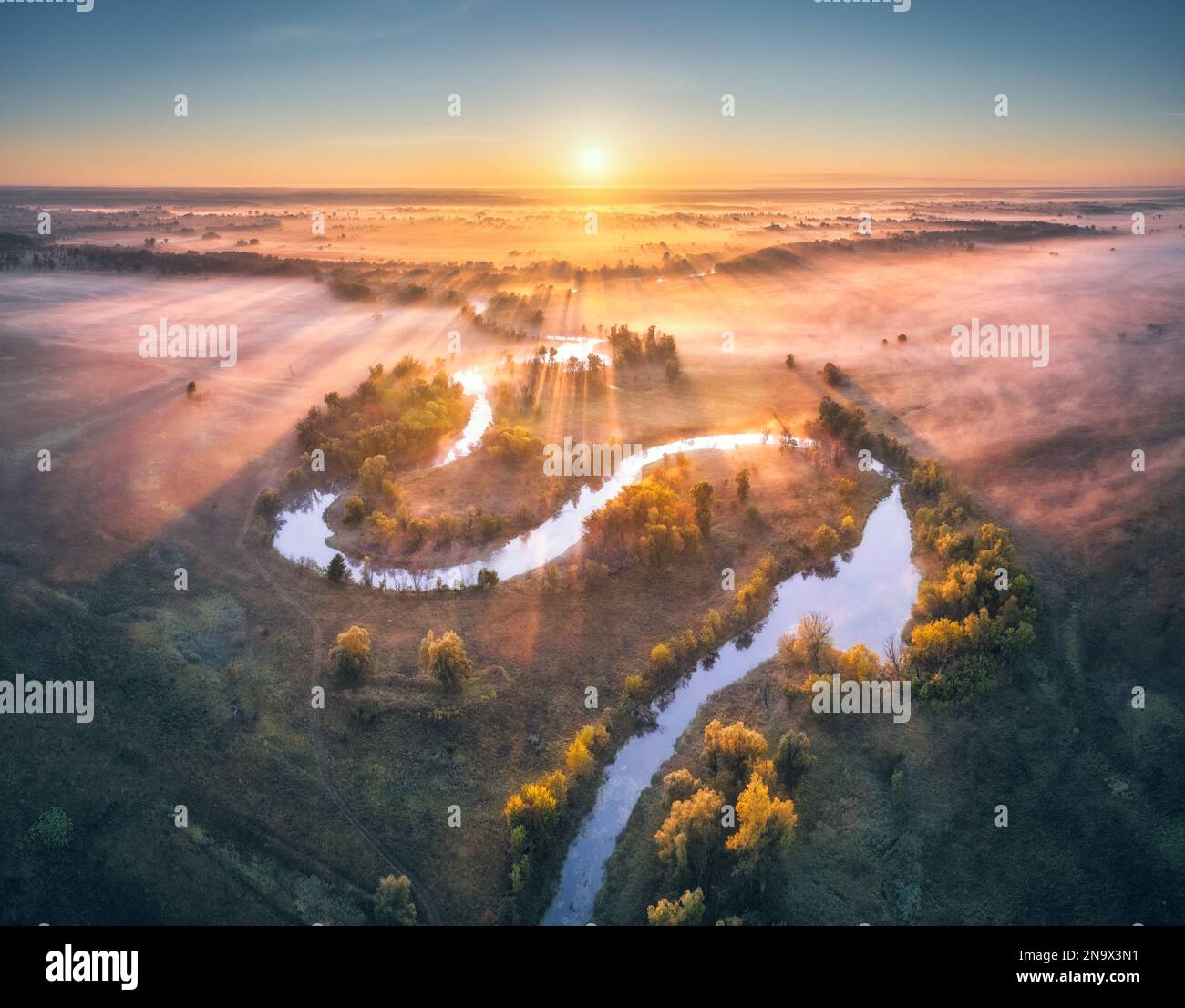 Aerial view of curving river in pink low clouds at sunrise Stock Photo ...