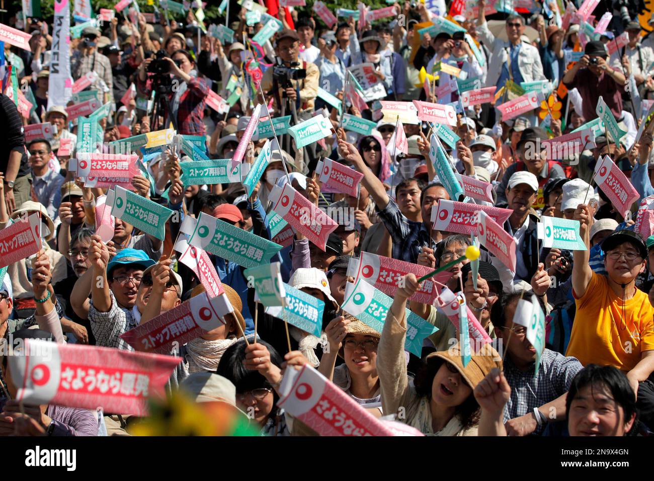 Participants raise banners with a slogan, "Good bye, nuclear power ...