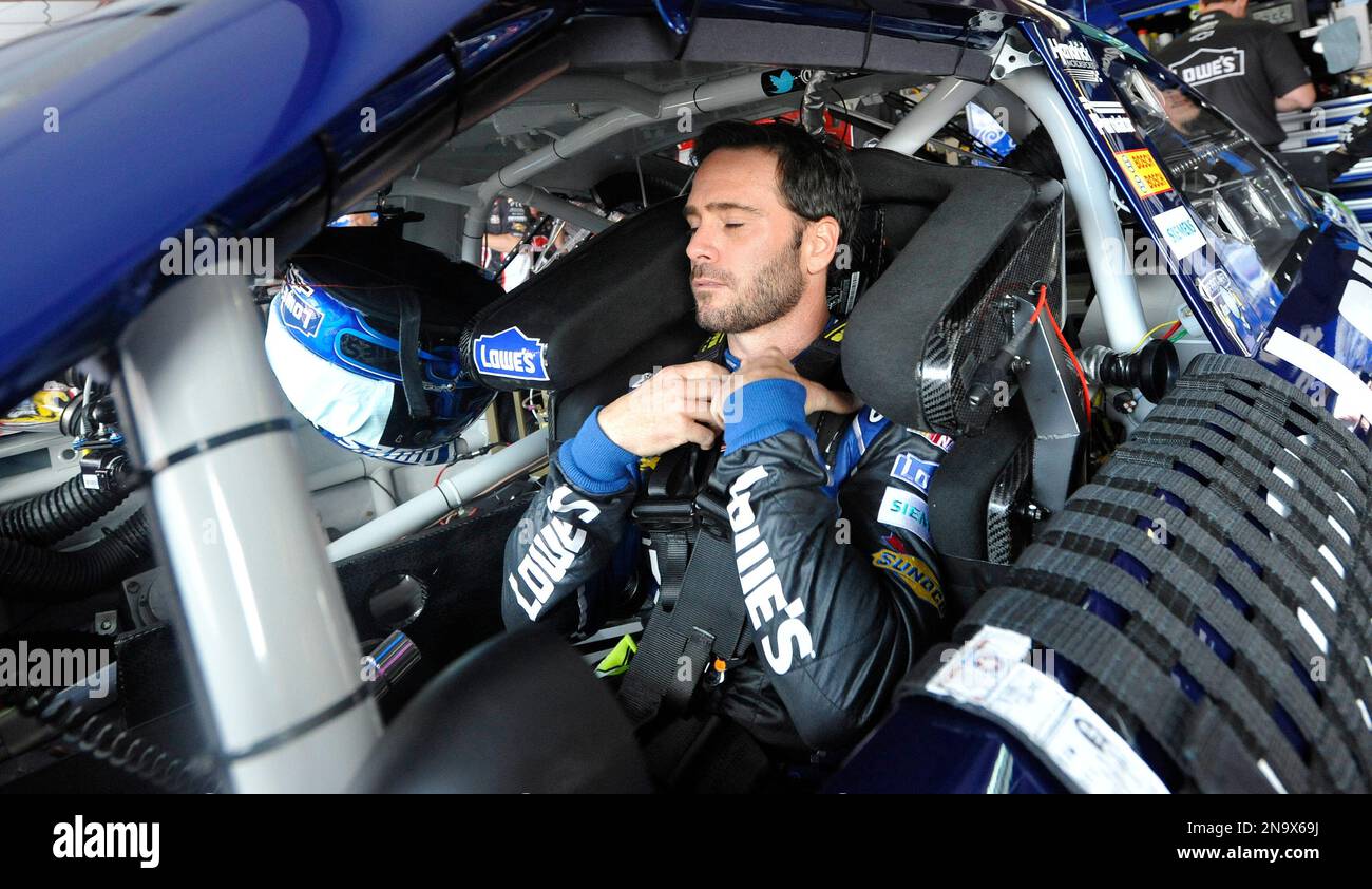 Driver Jimmie Johnson sits in his car as he prepares for NASCAR auto ...