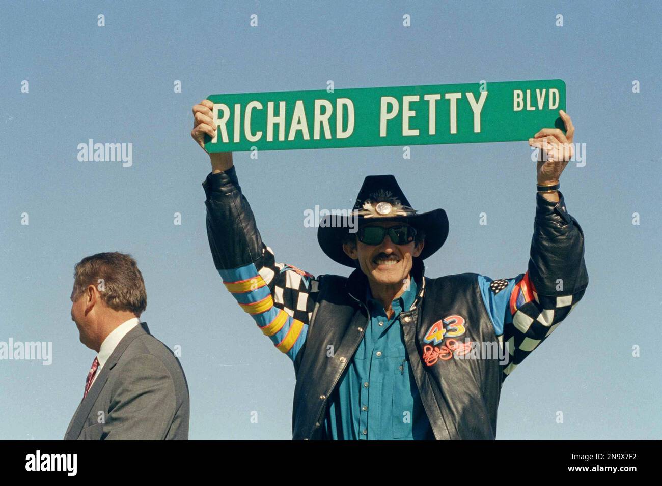 NASCAR driver Richard Petty holds up a street sign honoring him that ...
