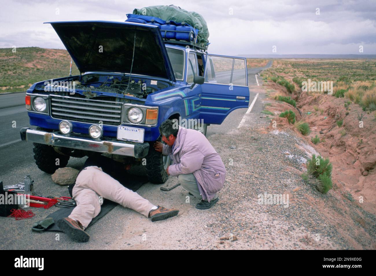 Two men work on a vehicle in the Atacama desert of Chile; Atacama ...