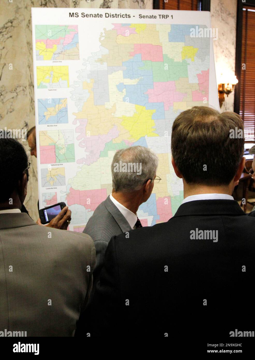 Senators crowd around an oversized map to get a first look at the new ...