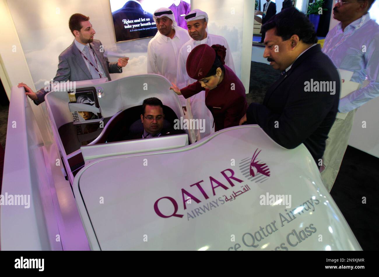 A Qatar airline stewardess demonstrates the new business class ...