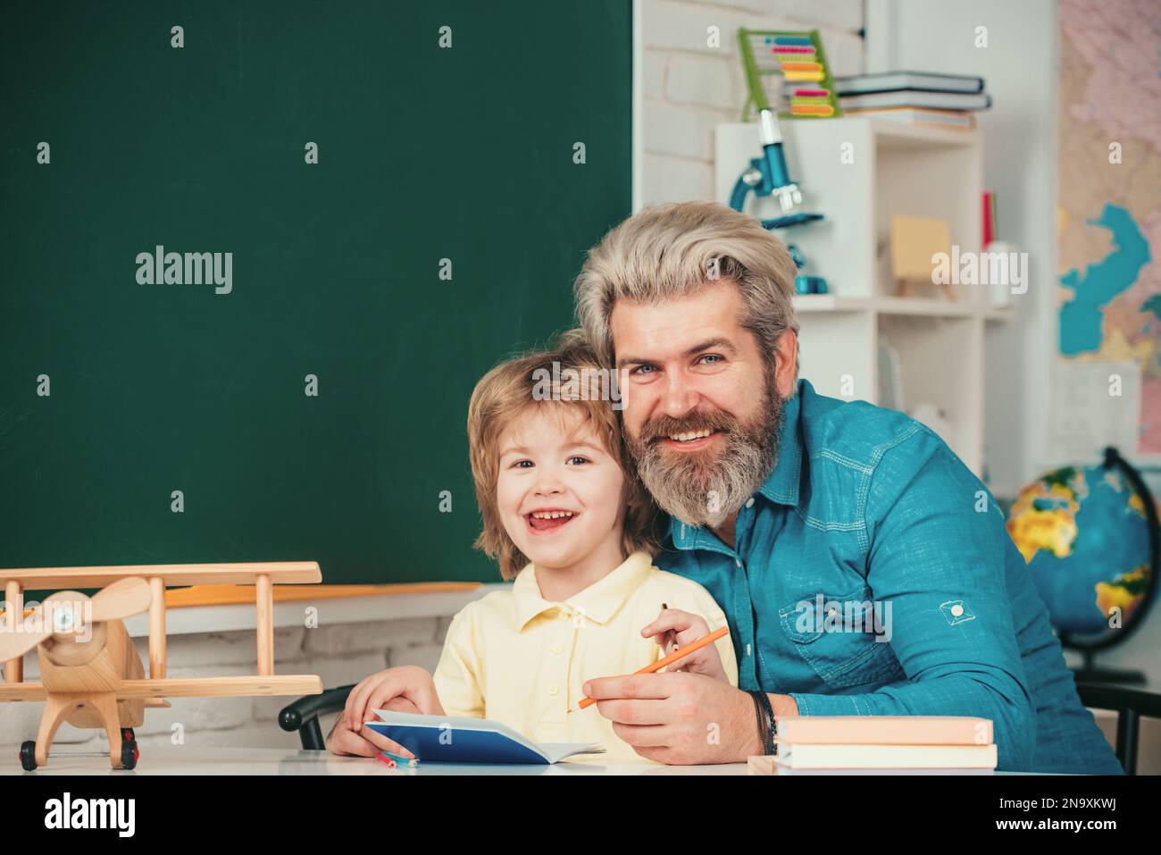 Father teaching son. School community partnership. Happy school kids at ...