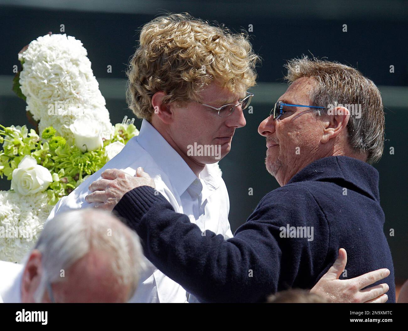 Nick Vos, left, boyfriend of Alexis Busch, is embraced during a ...