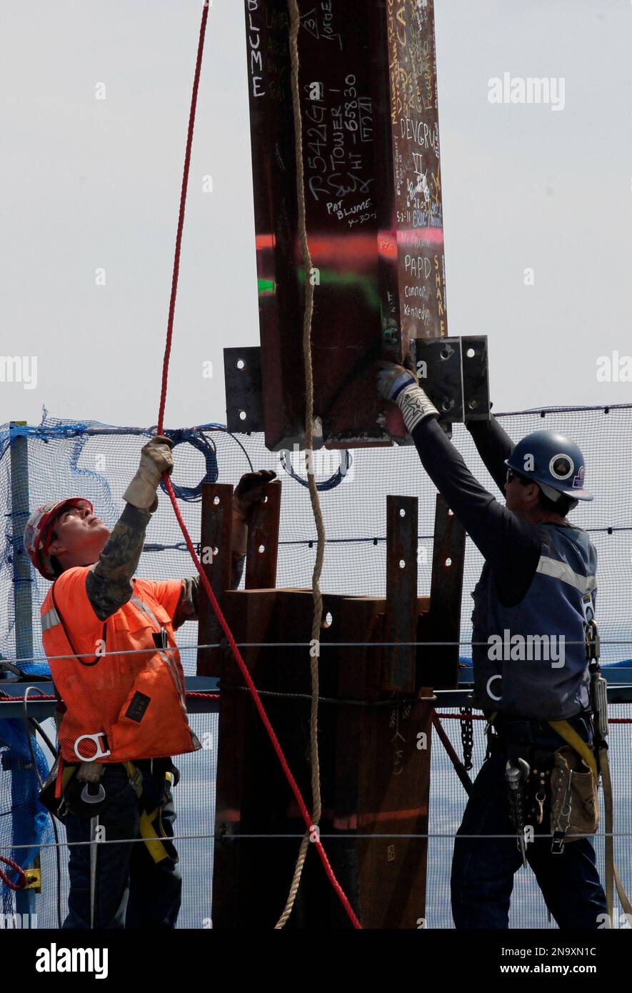 Ironworkers Adam Cross, left, and Steven Cross connect a steel beam ...
