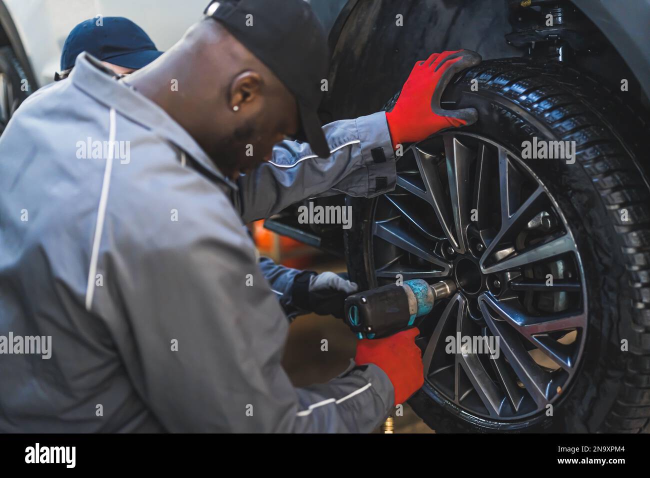 serviceman balancing a wheel with a tool, medium side view, auto repair ...