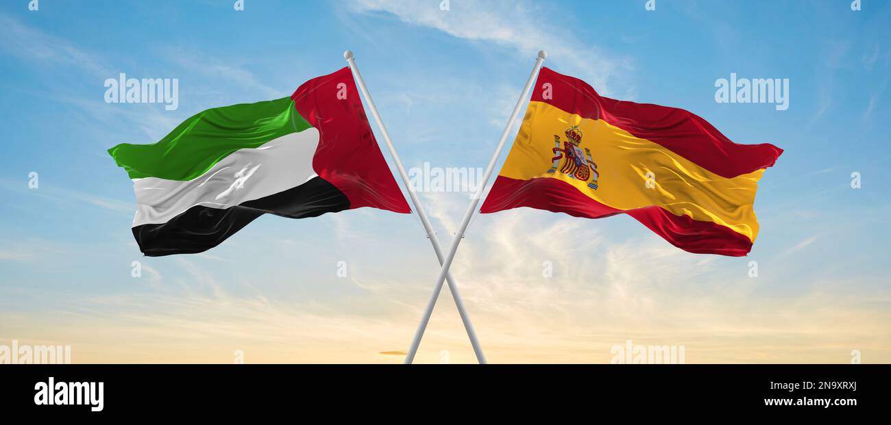 two crossed flags Spain and United Arab Emirates waving in wind at ...
