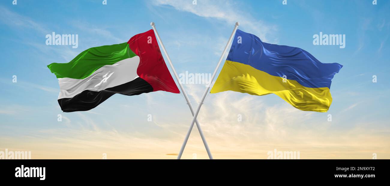 two crossed flags Ukraine and United Arab Emirates waving in wind at ...