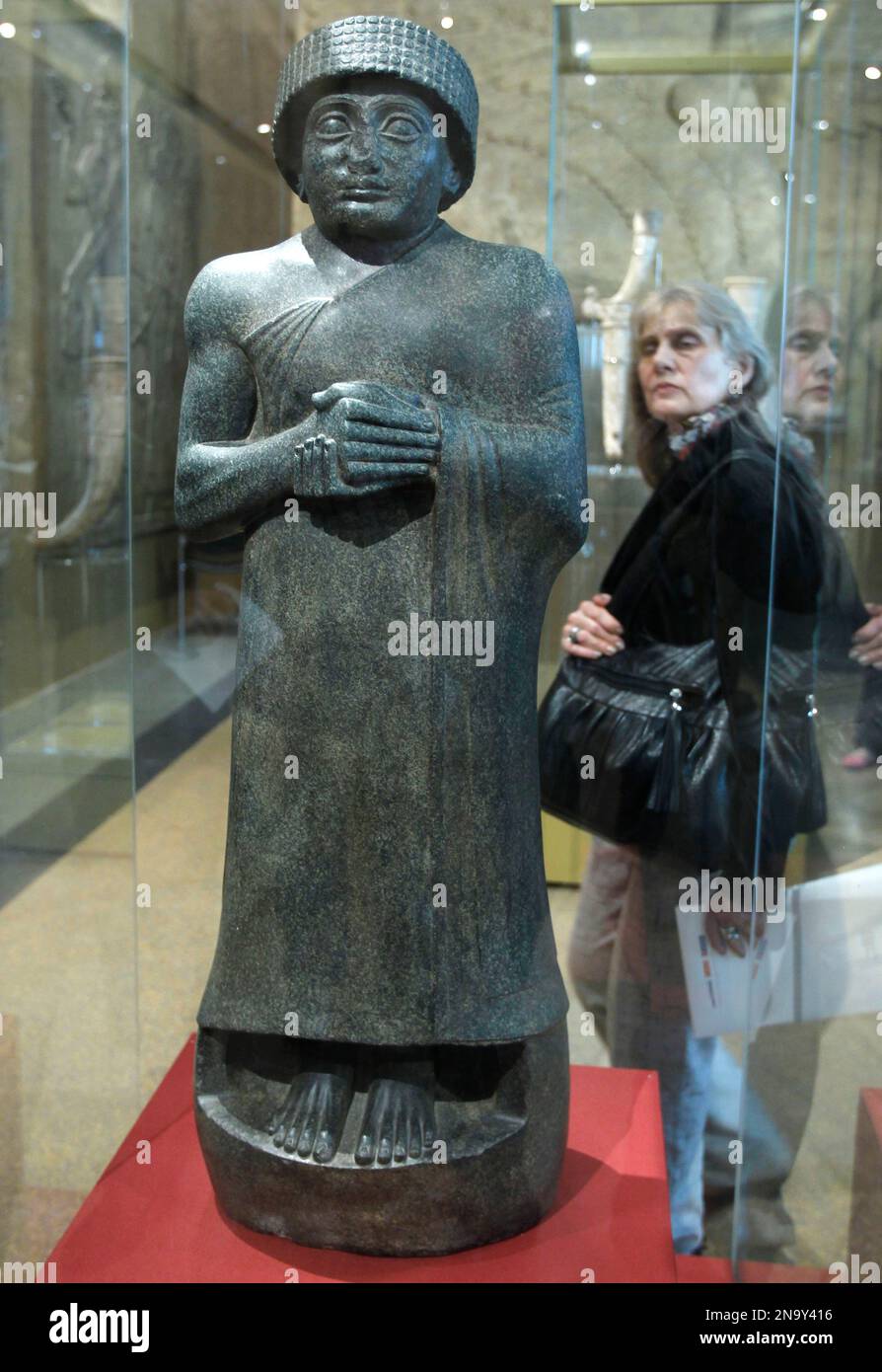 A visitor looks at Statue anepigraphe de Gudea from Louvre on display ...