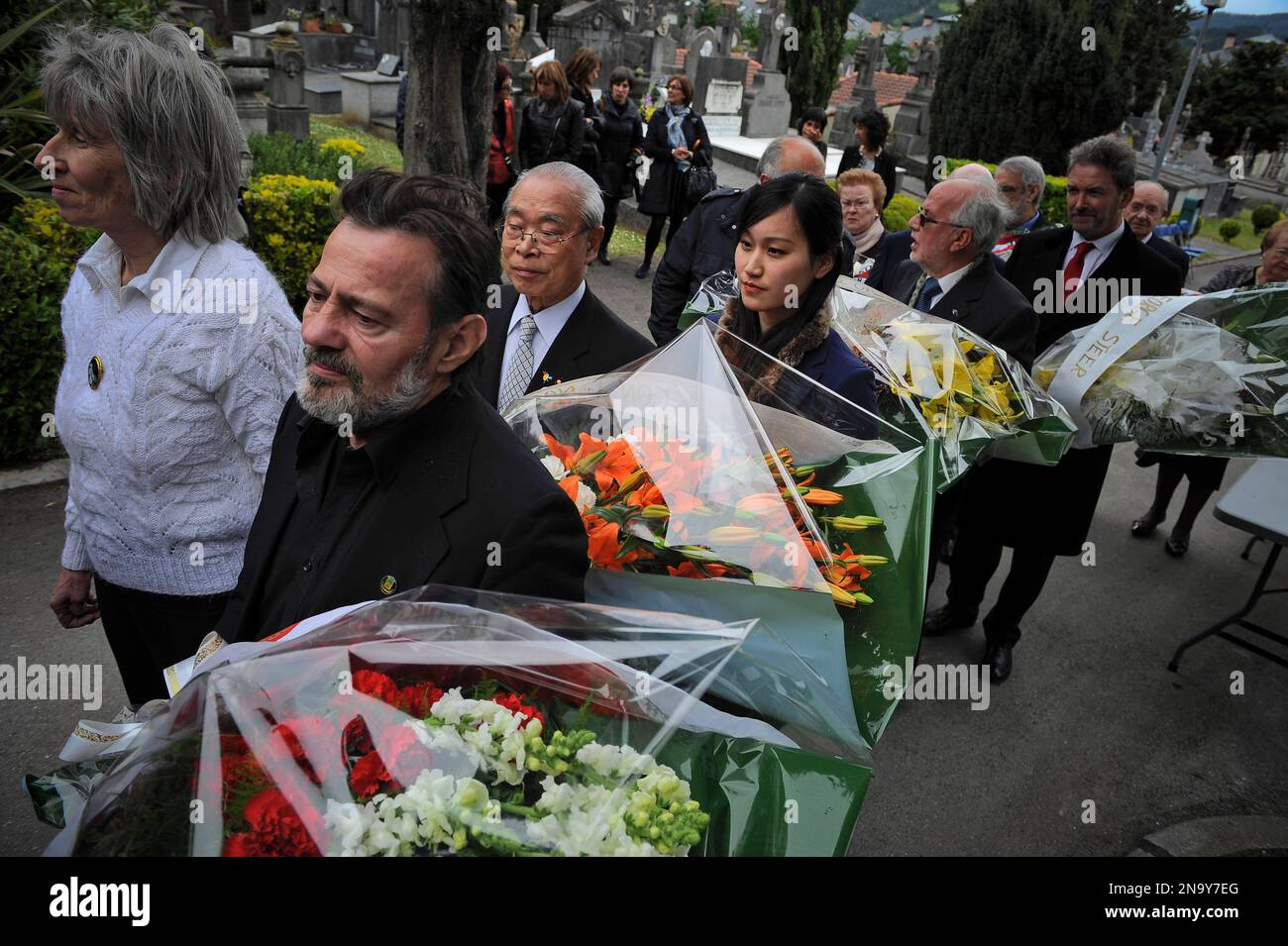 German and Japanese delegations, left to right, hold flowers when ...