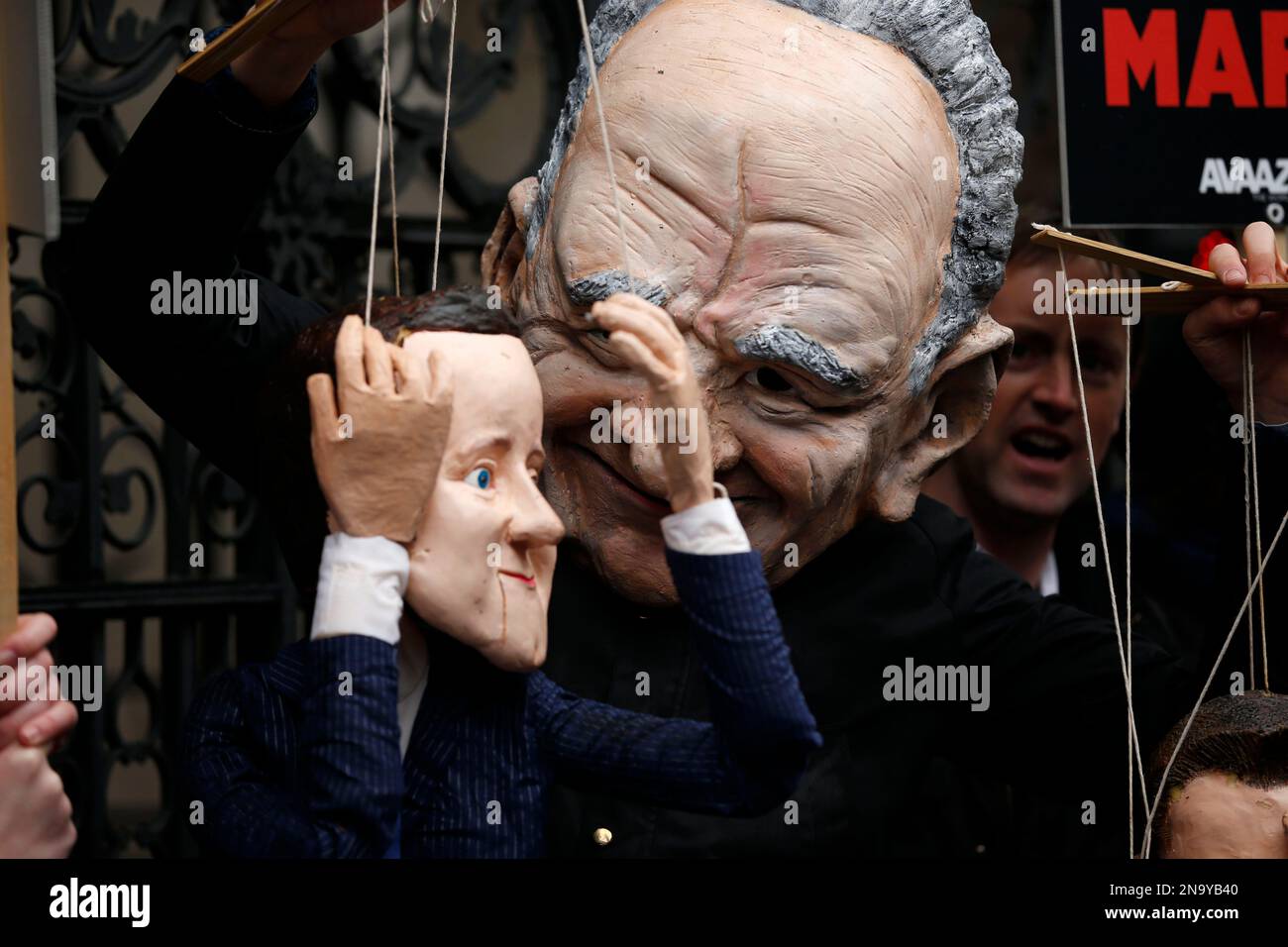 A protester wearing a Rupert Murdoch mask poses for photographers with ...