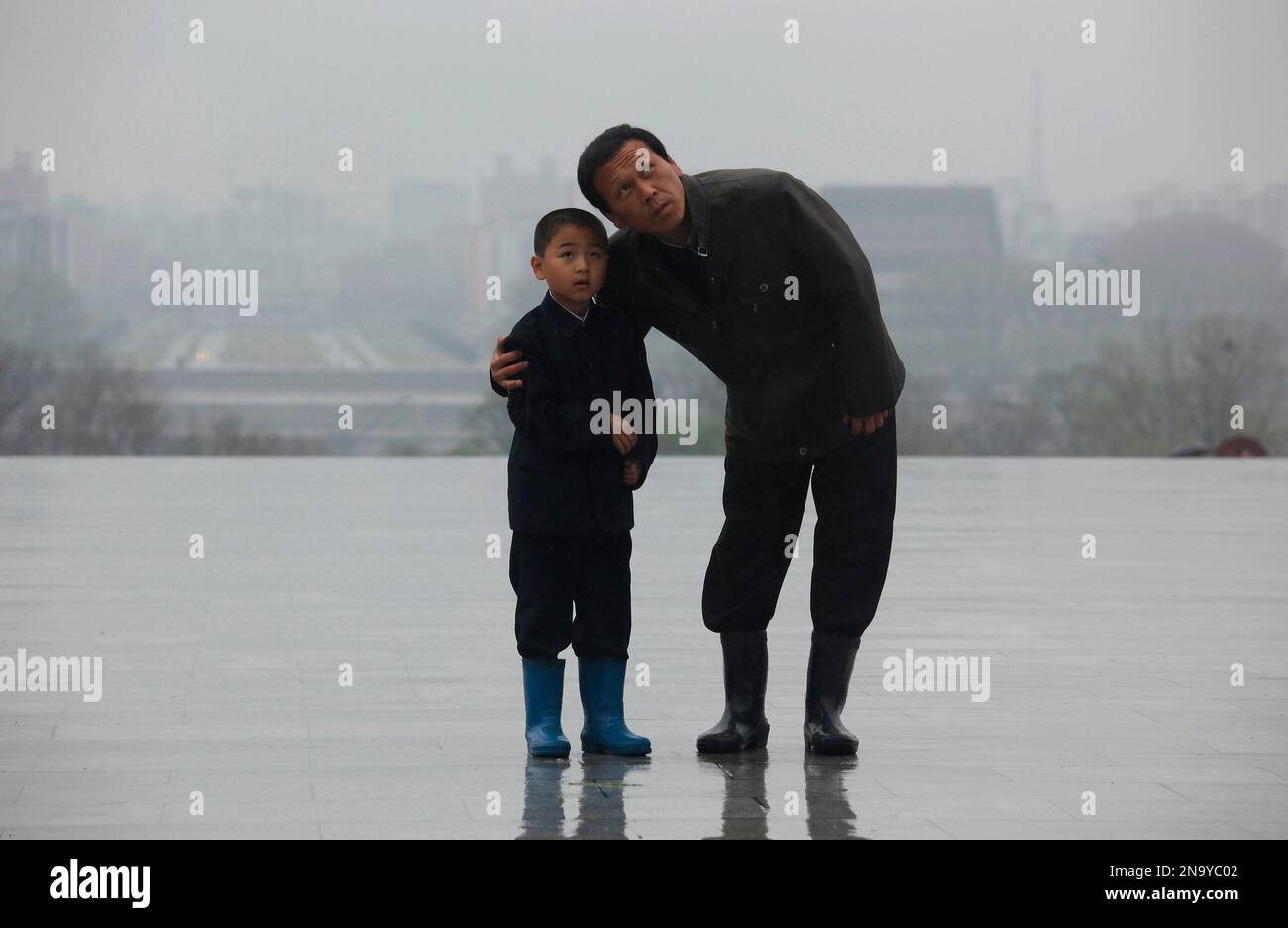 A North Korean father and his son look at the statues of late leaders ...