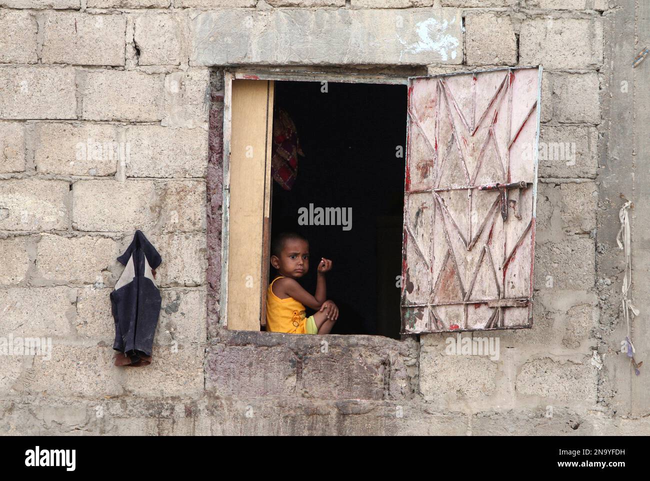 A Pakistani girl sits by the window of her home in a slum area in ...