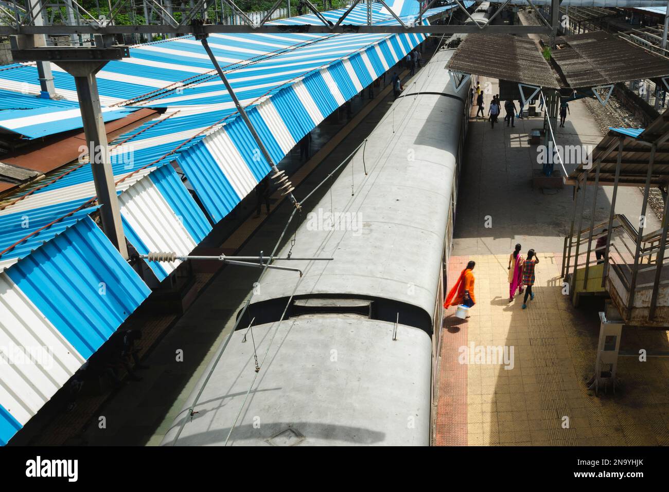 Elevated view of train arriving to Mahim railway station in Mumbai, India; Mumbai, Maharashtra ...